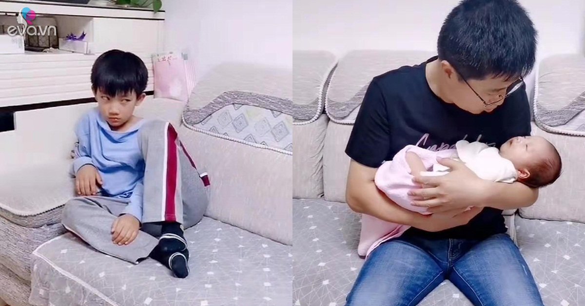 Bố bế con gái mới sinh, con trai lớn ngồi bên cạnh nhìn bằng ánh mắt ...